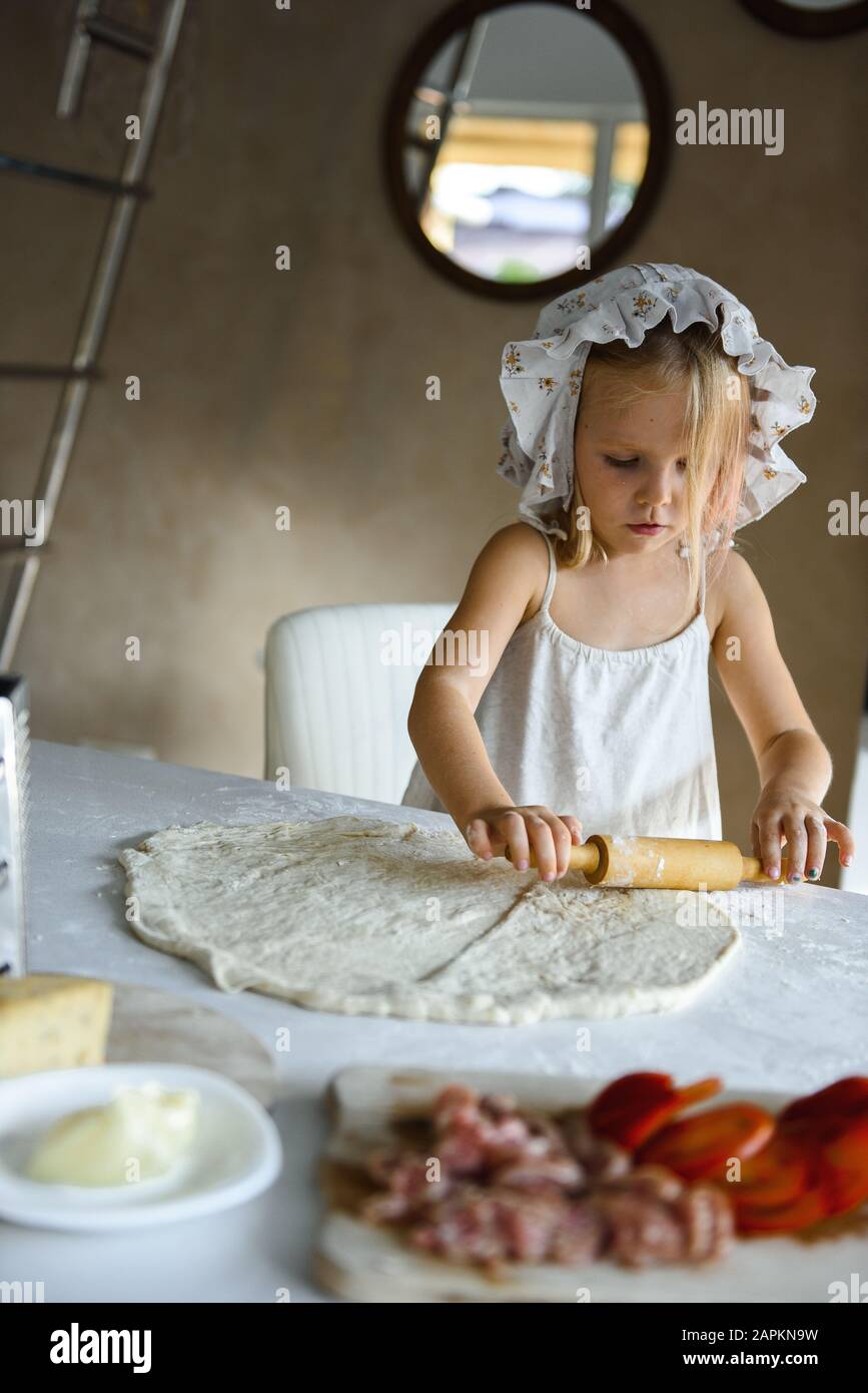Little girl cooking pizza in the kitchen Stock Photo - Alamy