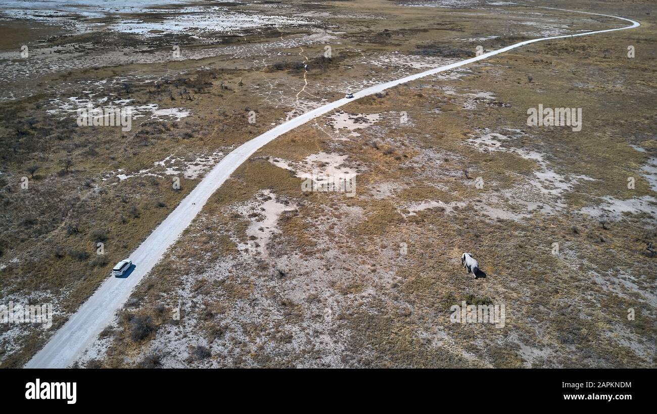 Aerial view of a jeep driving along a dirt track passing close to a ...