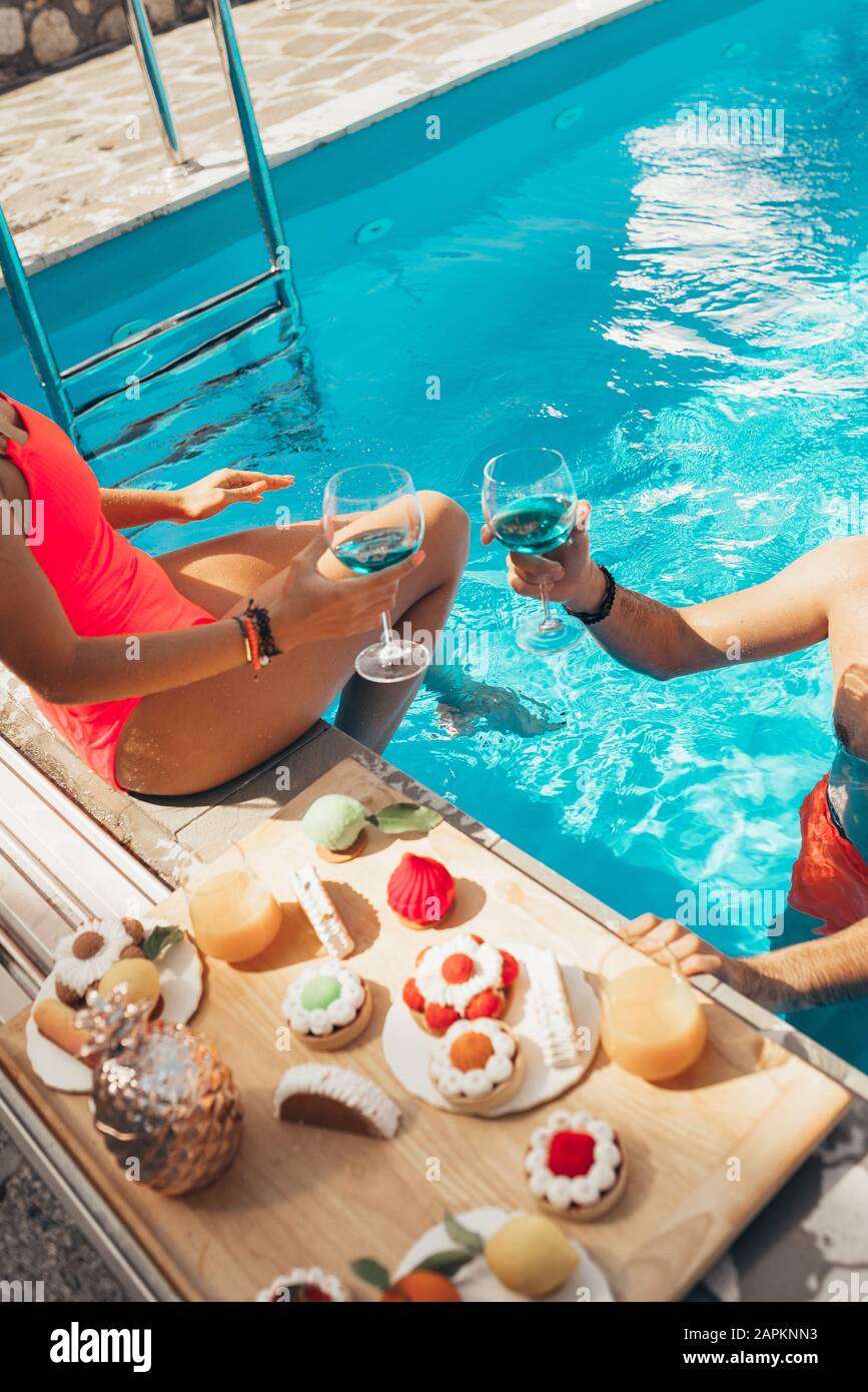 Boyfriend and girlfriend drinking wine by the pool Stock Photo - Alamy