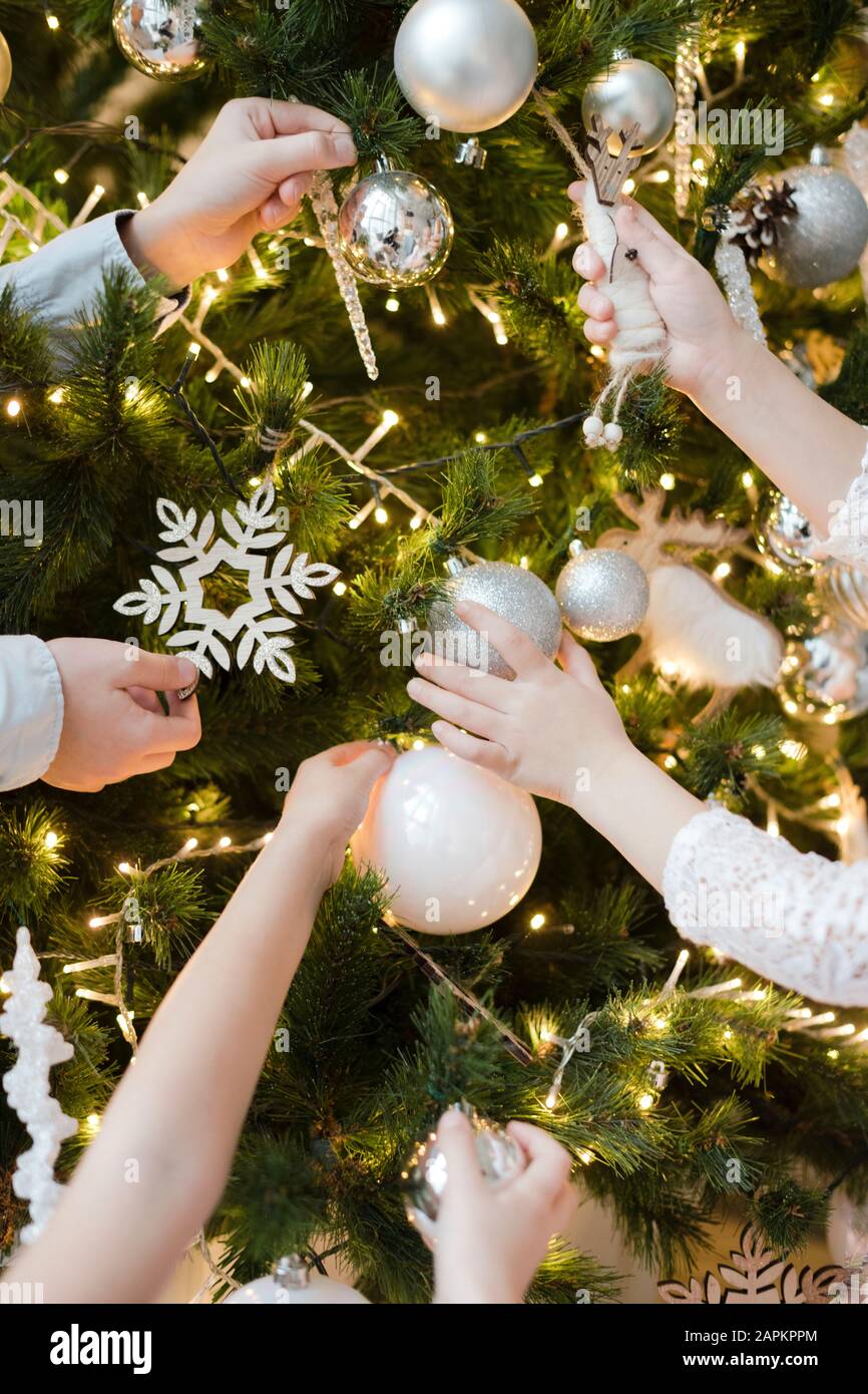 Crop view of children's hands decorating Christmas tree Stock Photo - Alamy