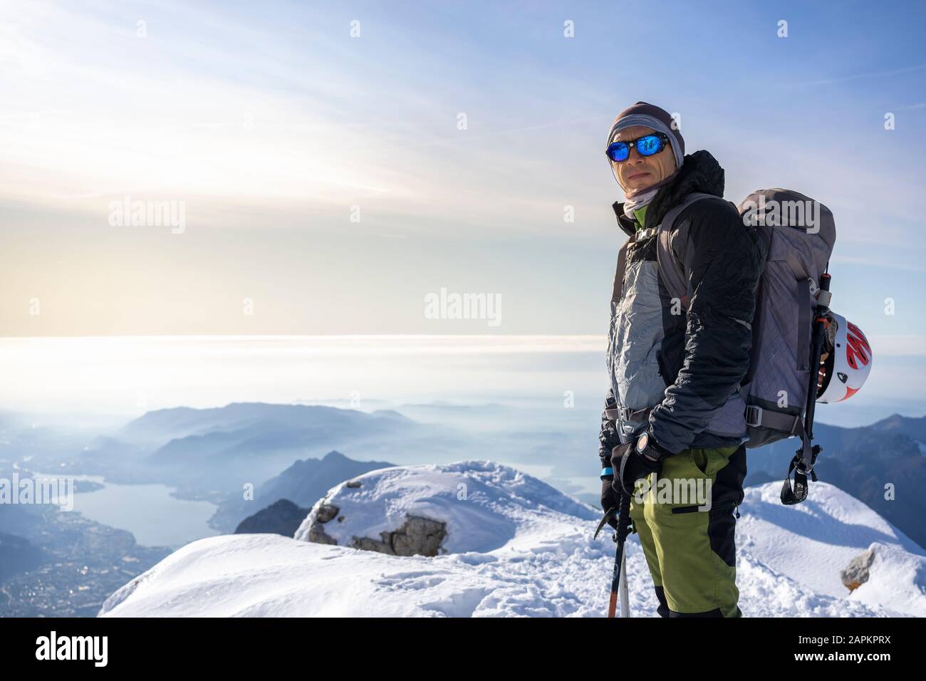 Portrait of an alpinist standing on snowy mountain peak, Orobie Alps ...