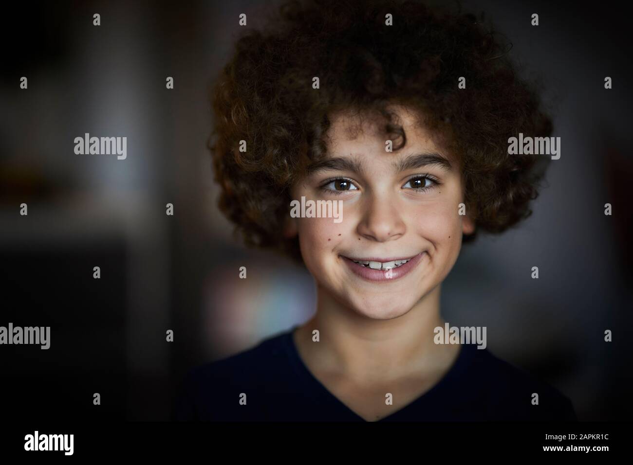 Portrait of smiling boy with brown ringlets Stock Photo - Alamy
