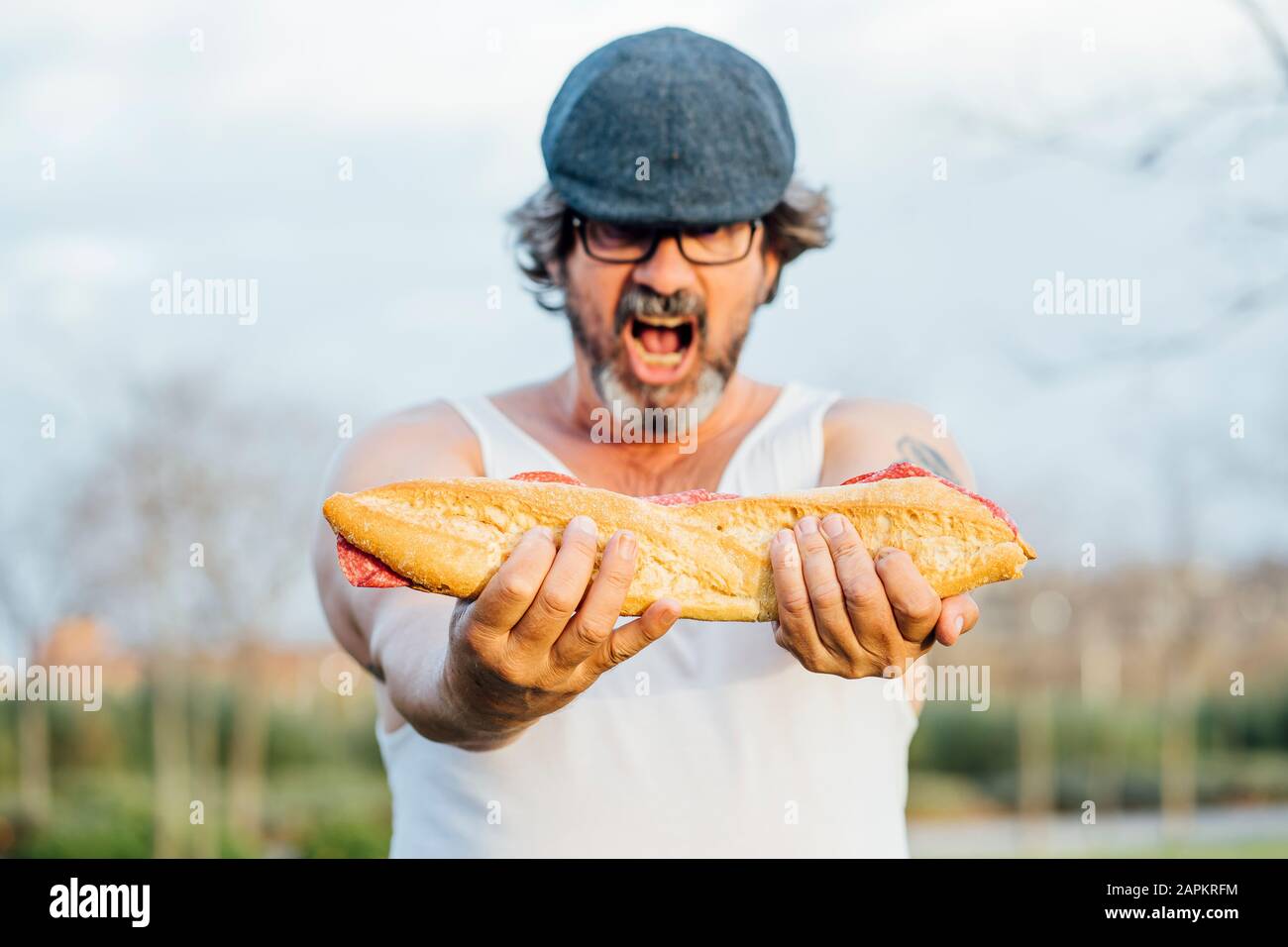 Man holding sandwich and screaming Stock Photo - Alamy