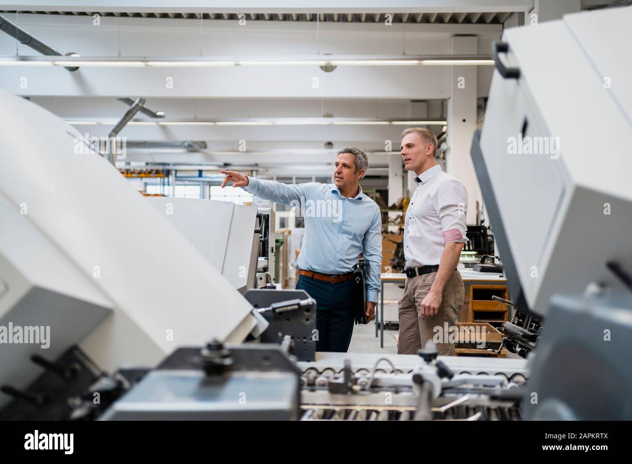 Two colleagues talking in a factory Stock Photo - Alamy