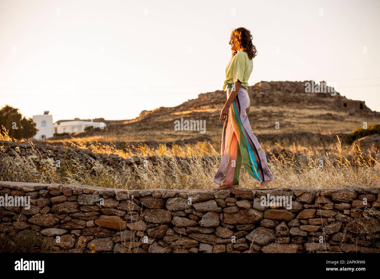Beautiful woman taking a walk at sunset, Mykonos, Greece Stock Photo ...