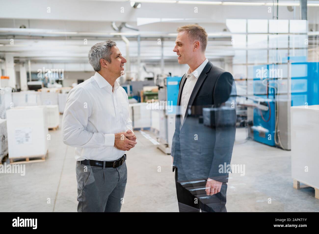 Two businessmen talking in a factory Stock Photo - Alamy