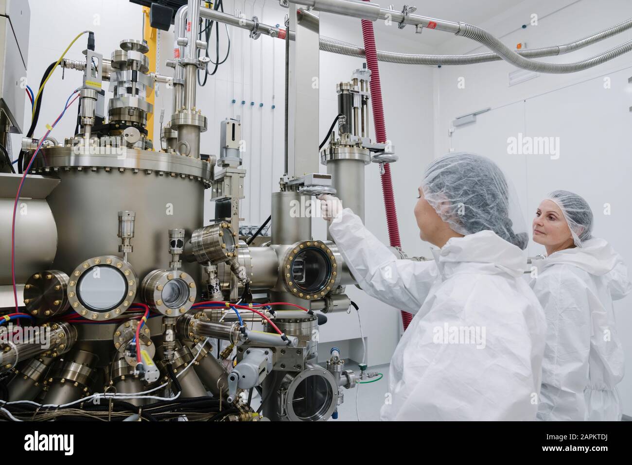 Laboratory technicians working on a device in laboratory of science ...