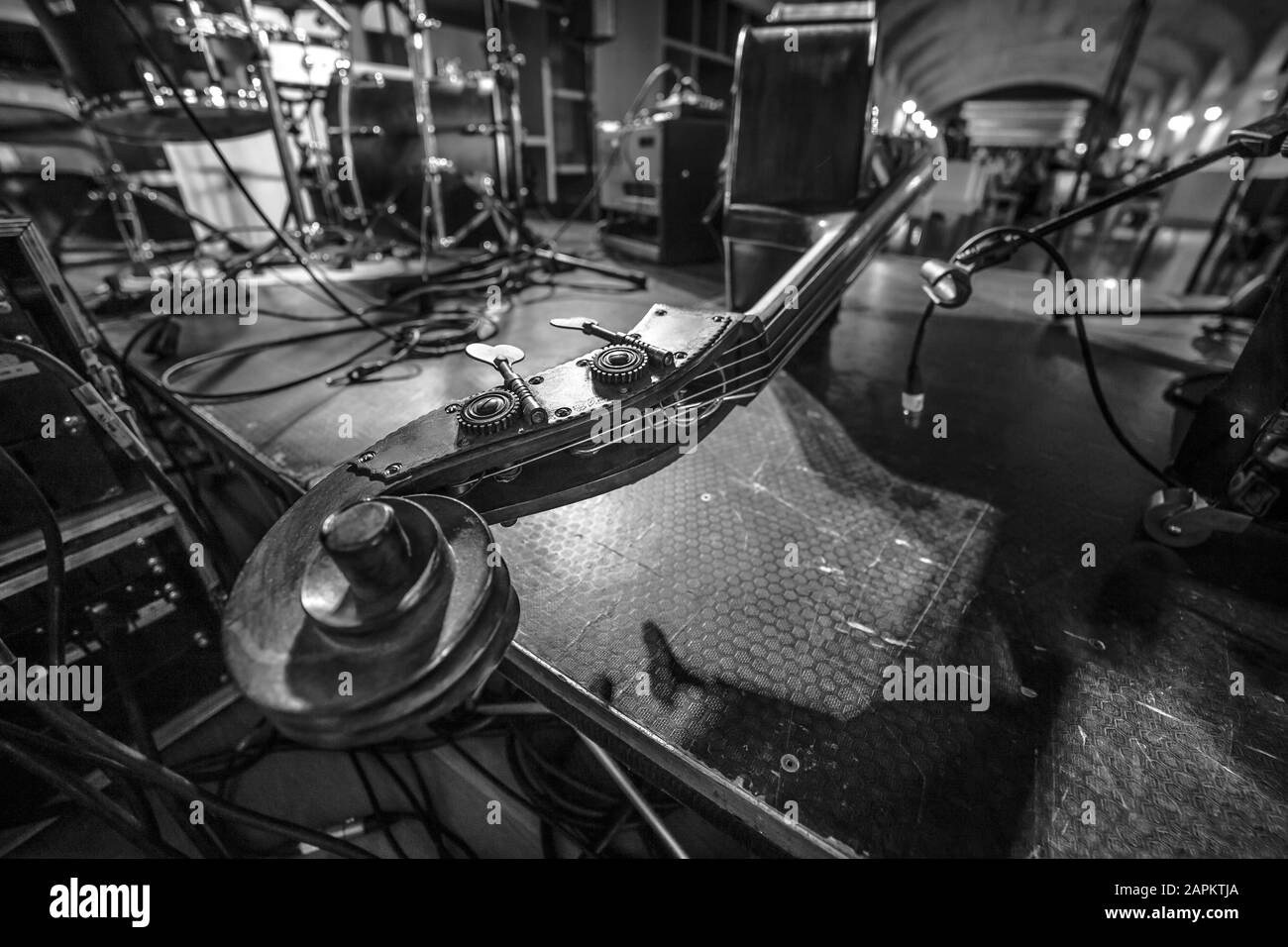 Closeup grayscale shot of a scroll of a giant violin with a blurred ...