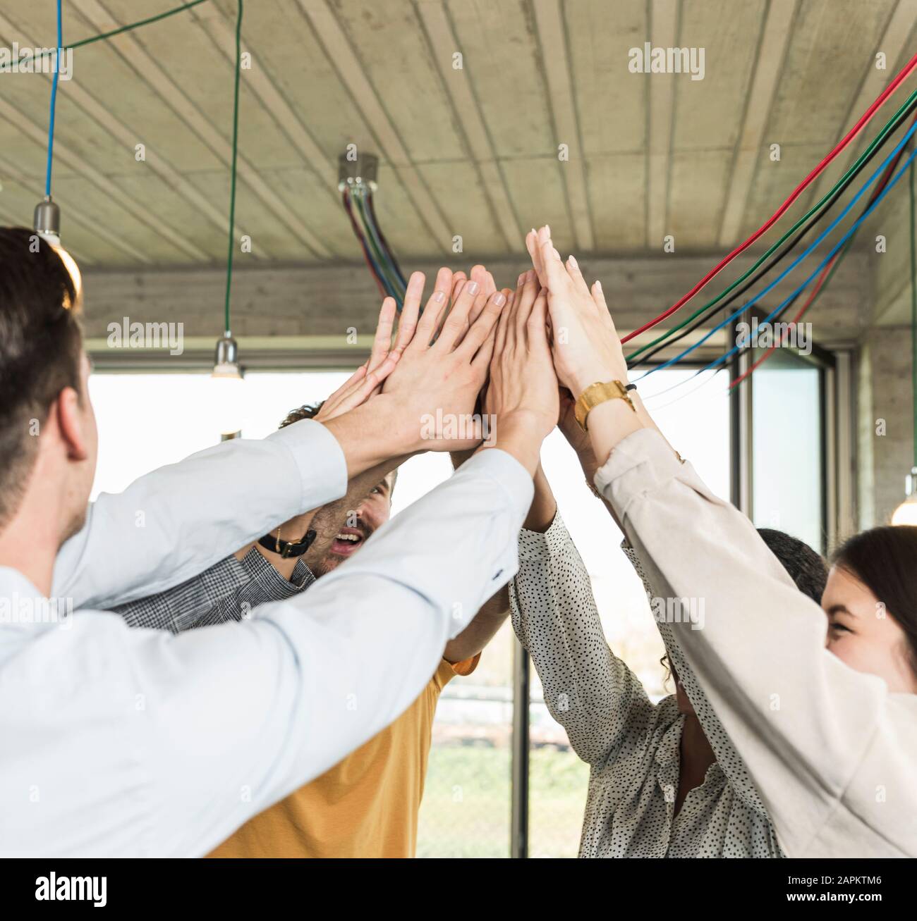Happy young business people raising their arms in office Stock Photo ...
