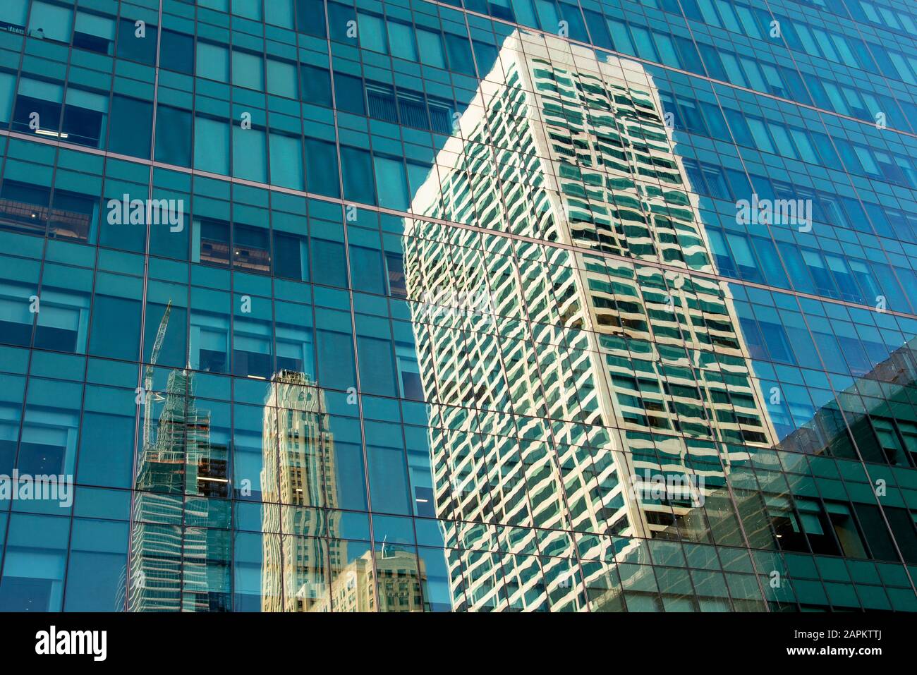 USA, New York, New York City, Skyscraper reflecting in glass wall of ...