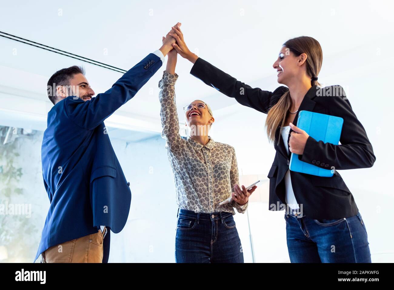 Business people high fiving in office Stock Photo - Alamy