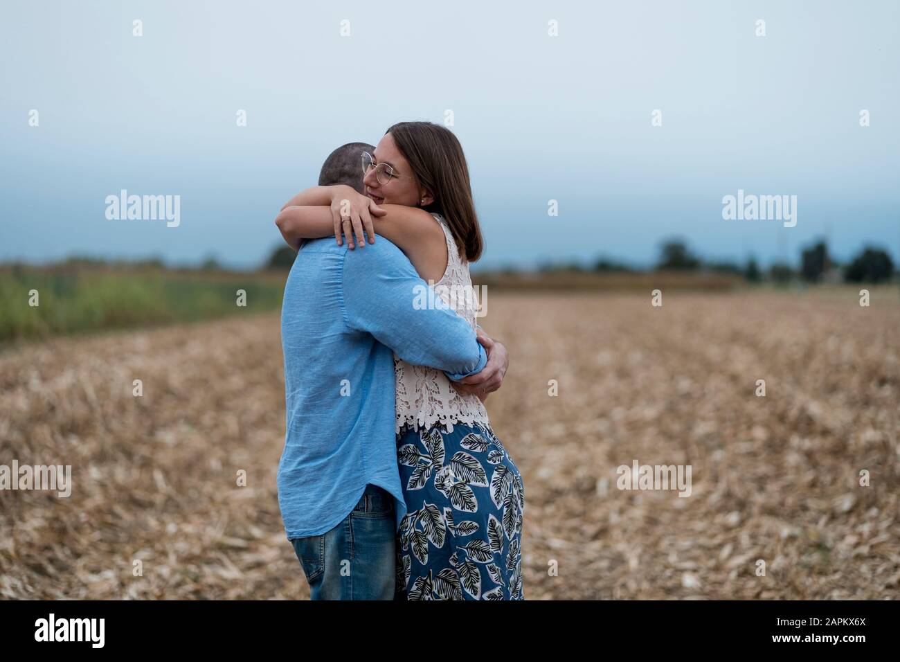 Couple in love hugging on a field Stock Photo - Alamy