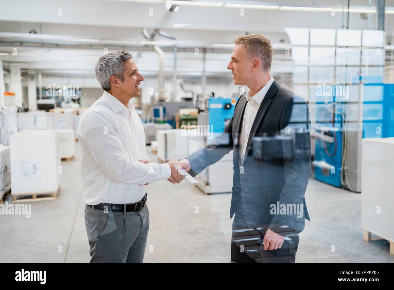 Two businessmen shaking hands in a factory Stock Photo - Alamy