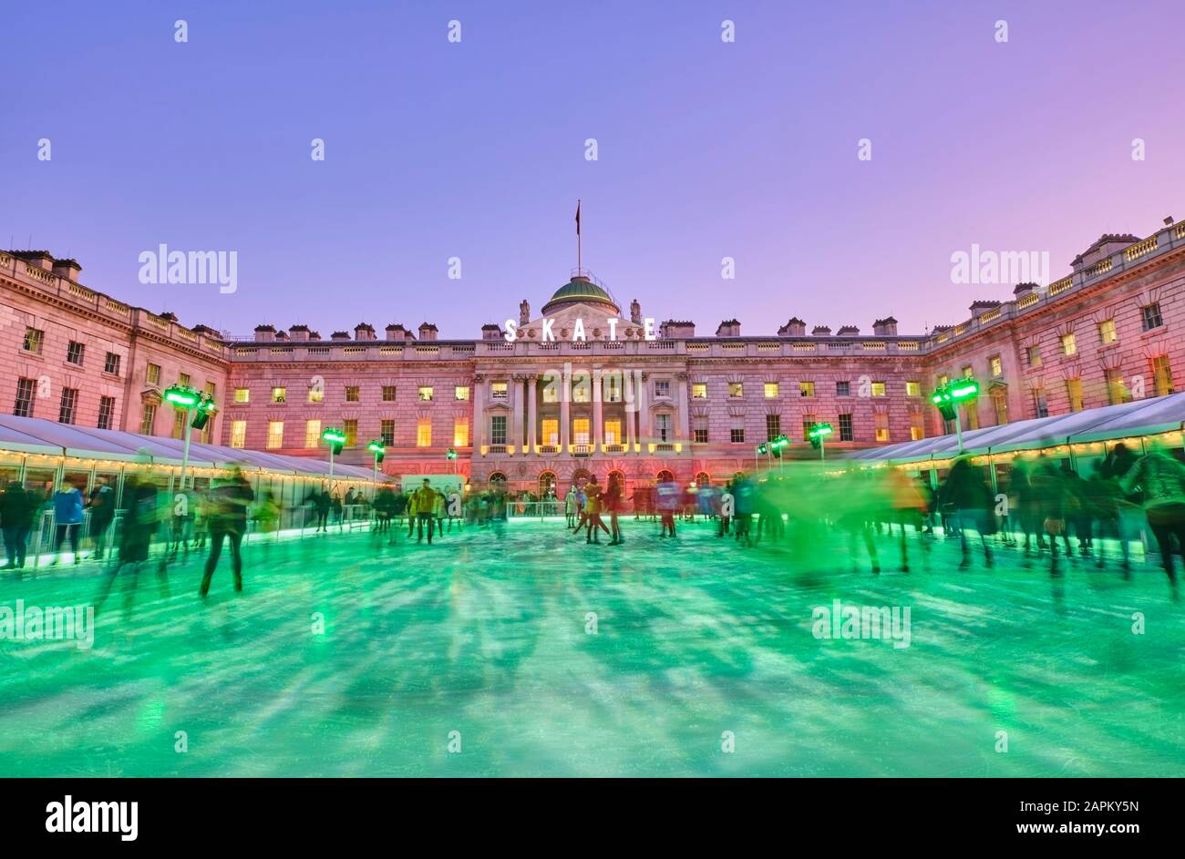 UK, England, London, People ice-skating in green ice rink in front of ...