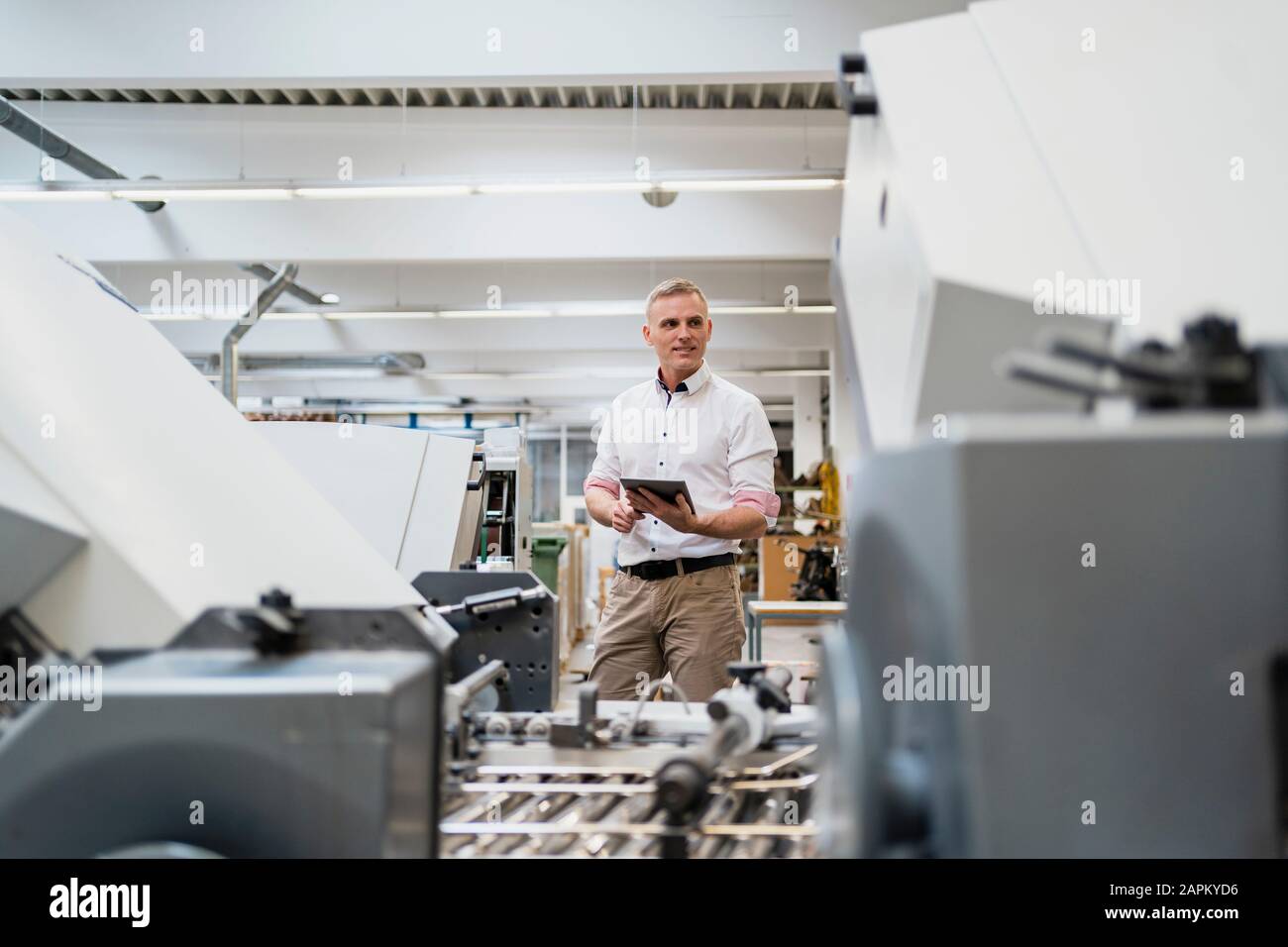 Businessman using a tablet in a factory Stock Photo - Alamy