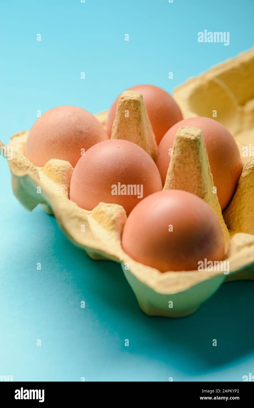 View of opened box of chicken eggs, blue background Stock Photo - Alamy