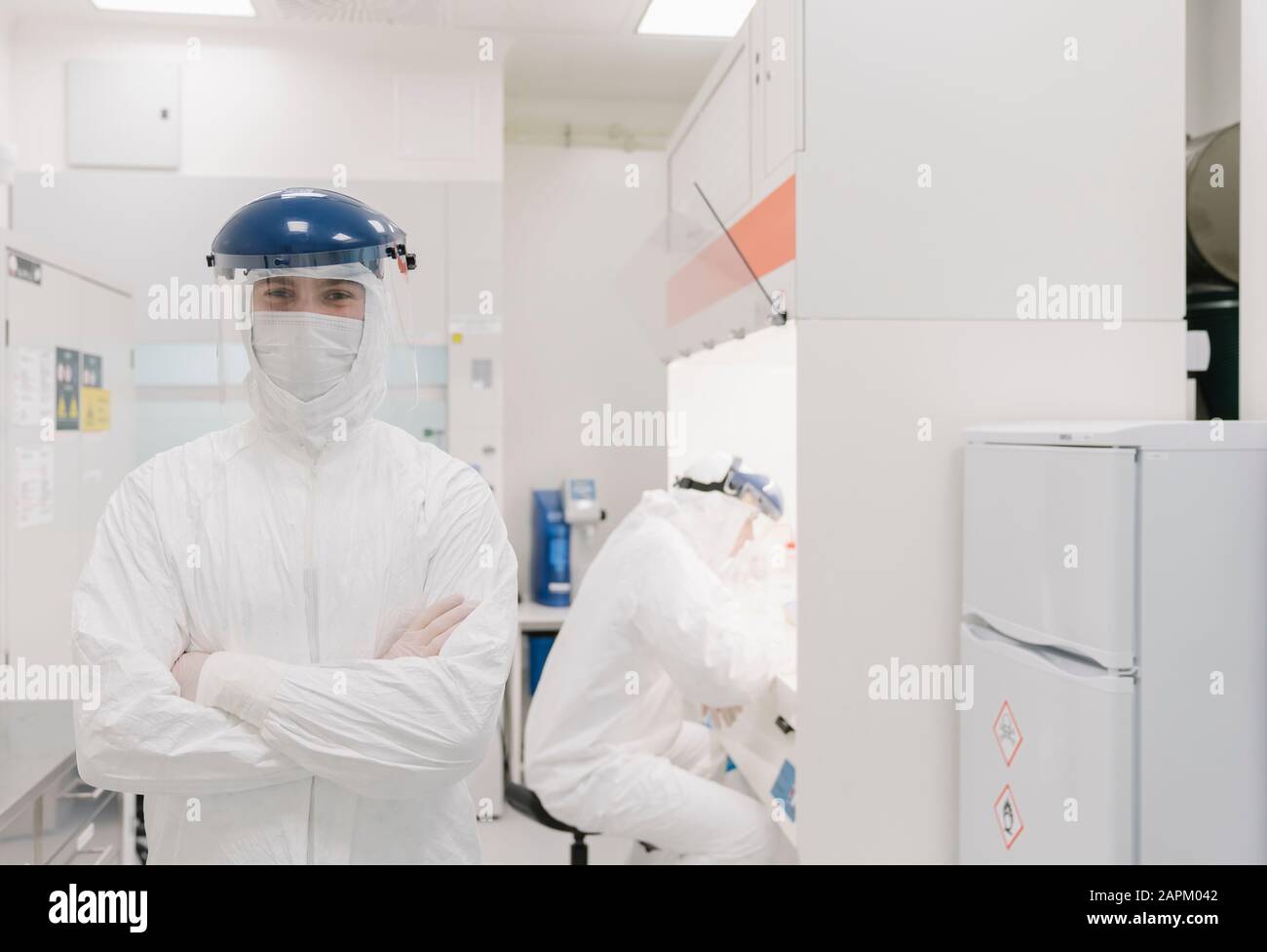 Portrait of confident scientist wearing safety helmet in laboratory ...
