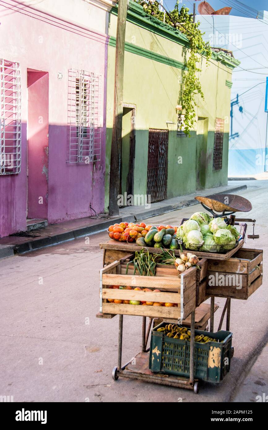 A wooden fruit cart stacked with fruits and vegetables for sale ...