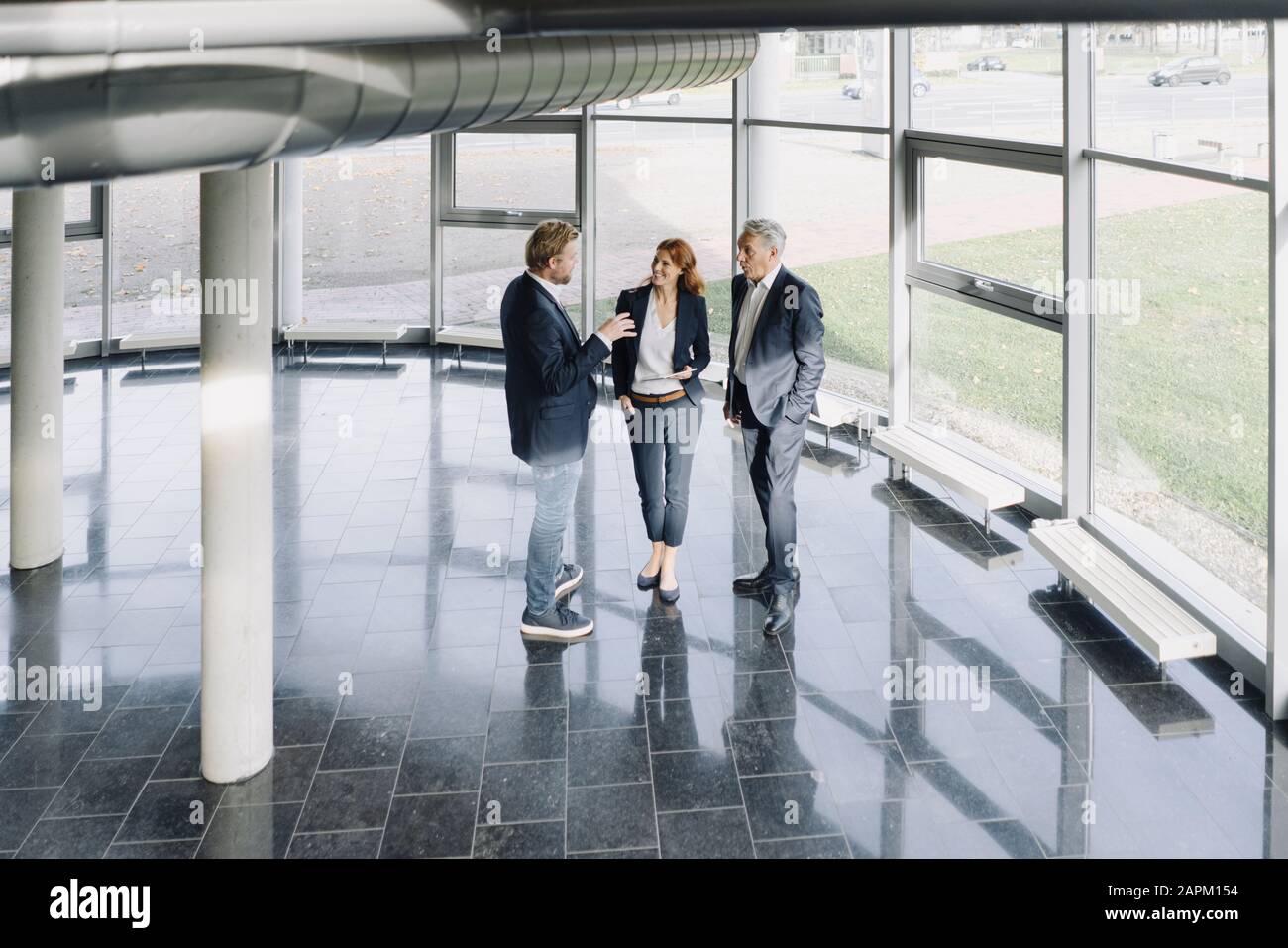 Business people talking at the window in modern office building Stock ...