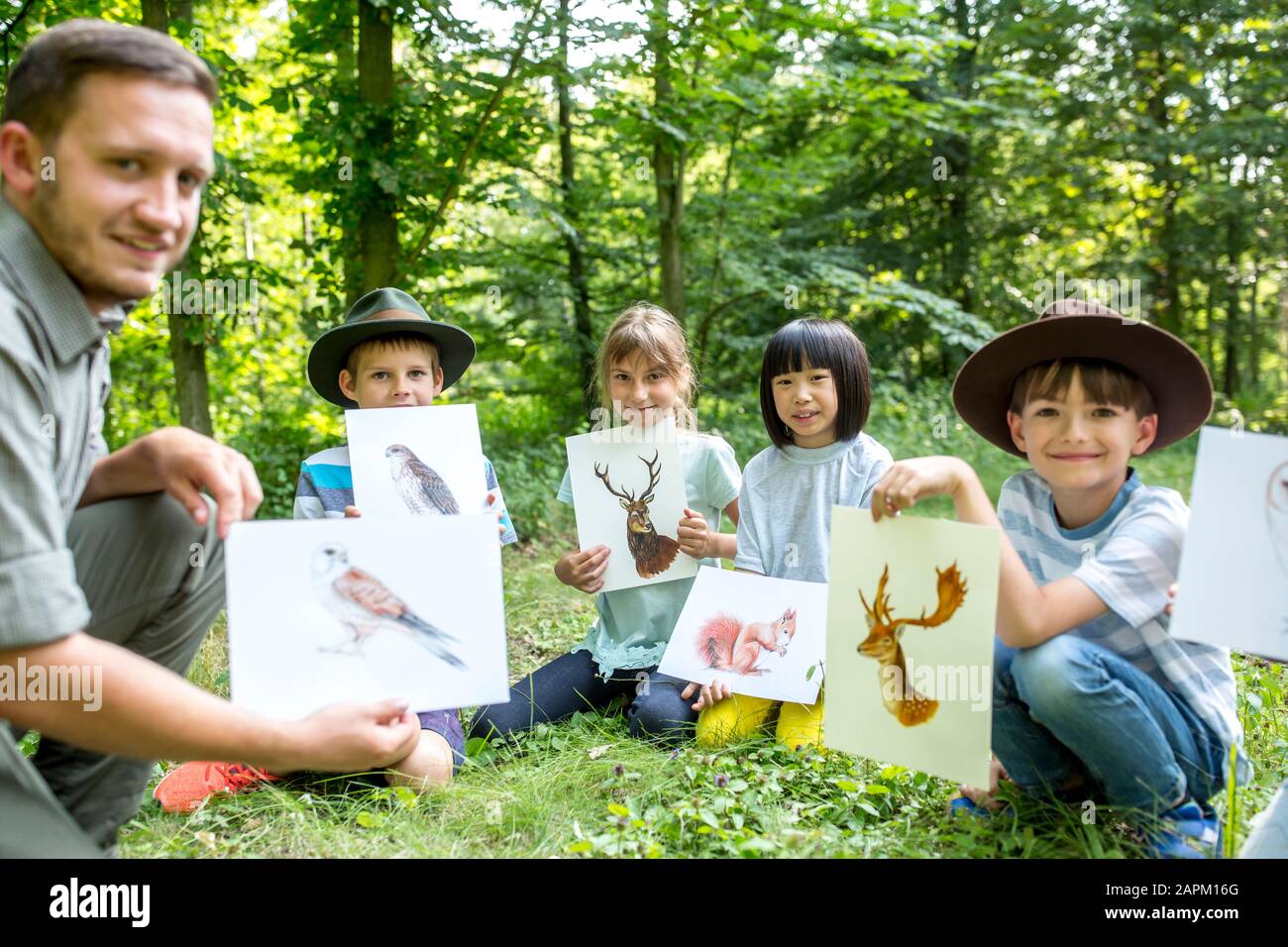School children doung nature studies, holding pictures of animals Stock ...