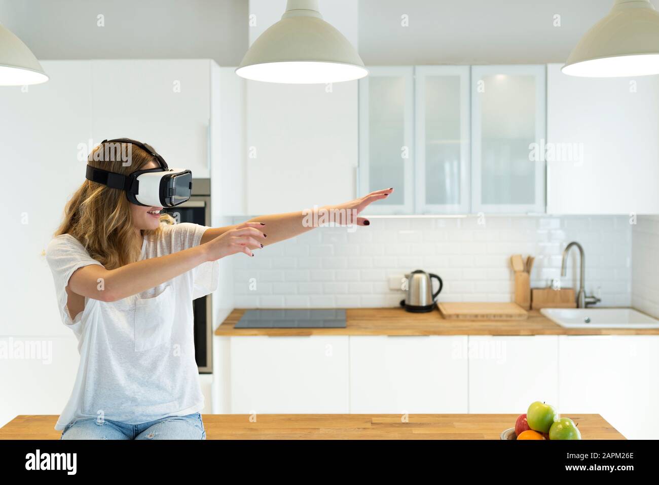 Female teenager in the kitchen with VR glasses Stock Photo - Alamy