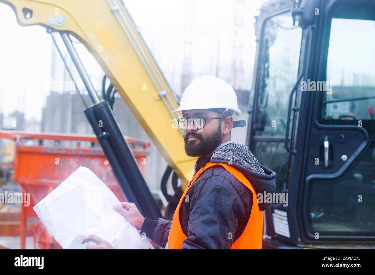 Construction engineer at construction site wearing hard hat and safety ...