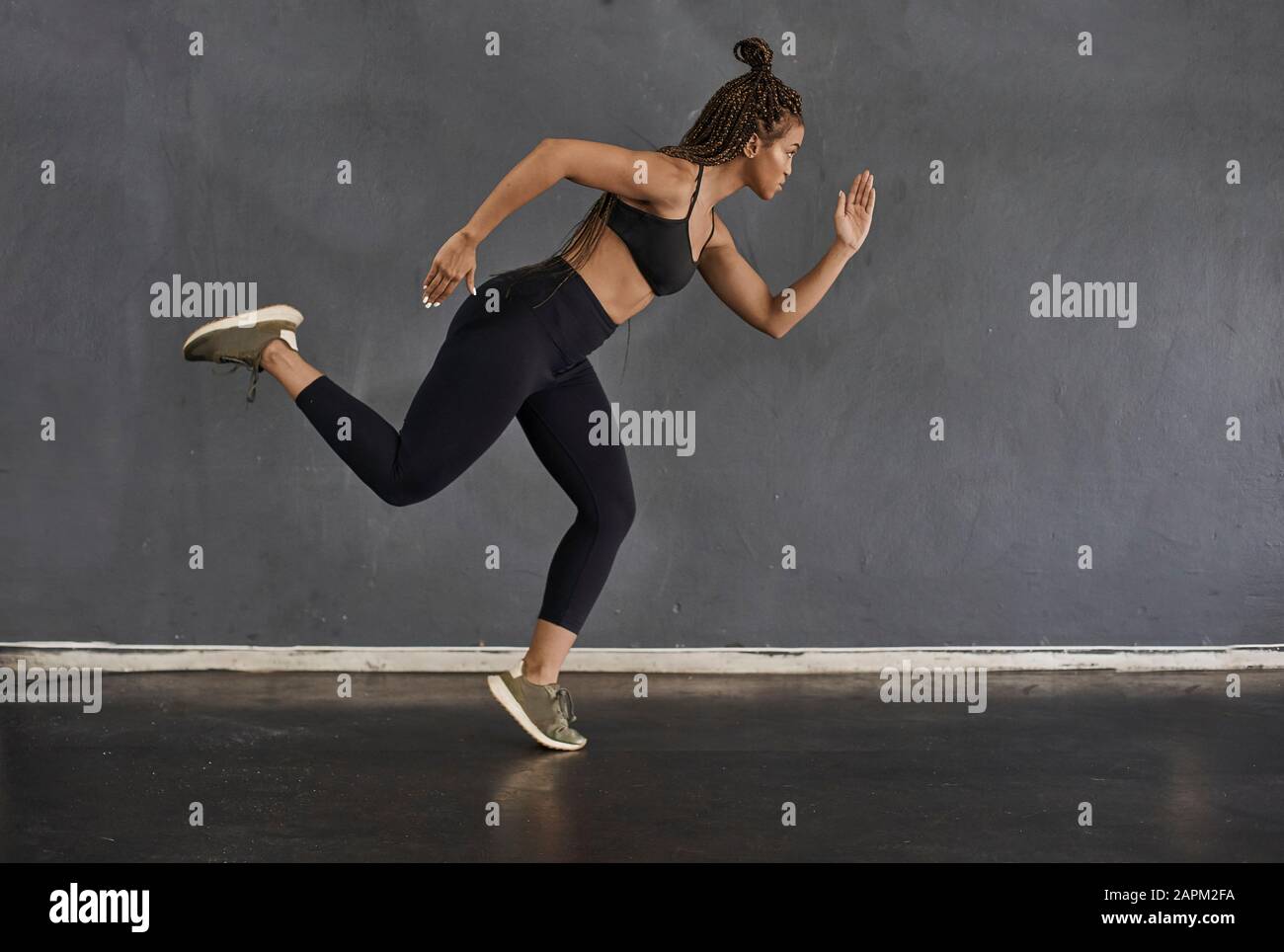 Female athlete doing running exercises in gym Stock Photo - Alamy