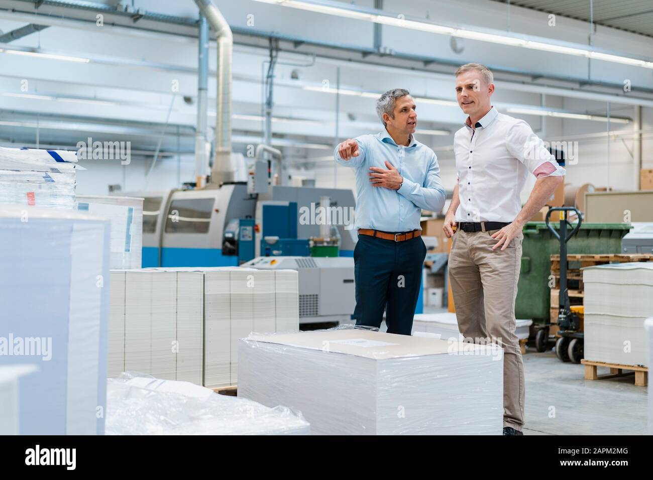 Two colleagues talking in a factory Stock Photo - Alamy