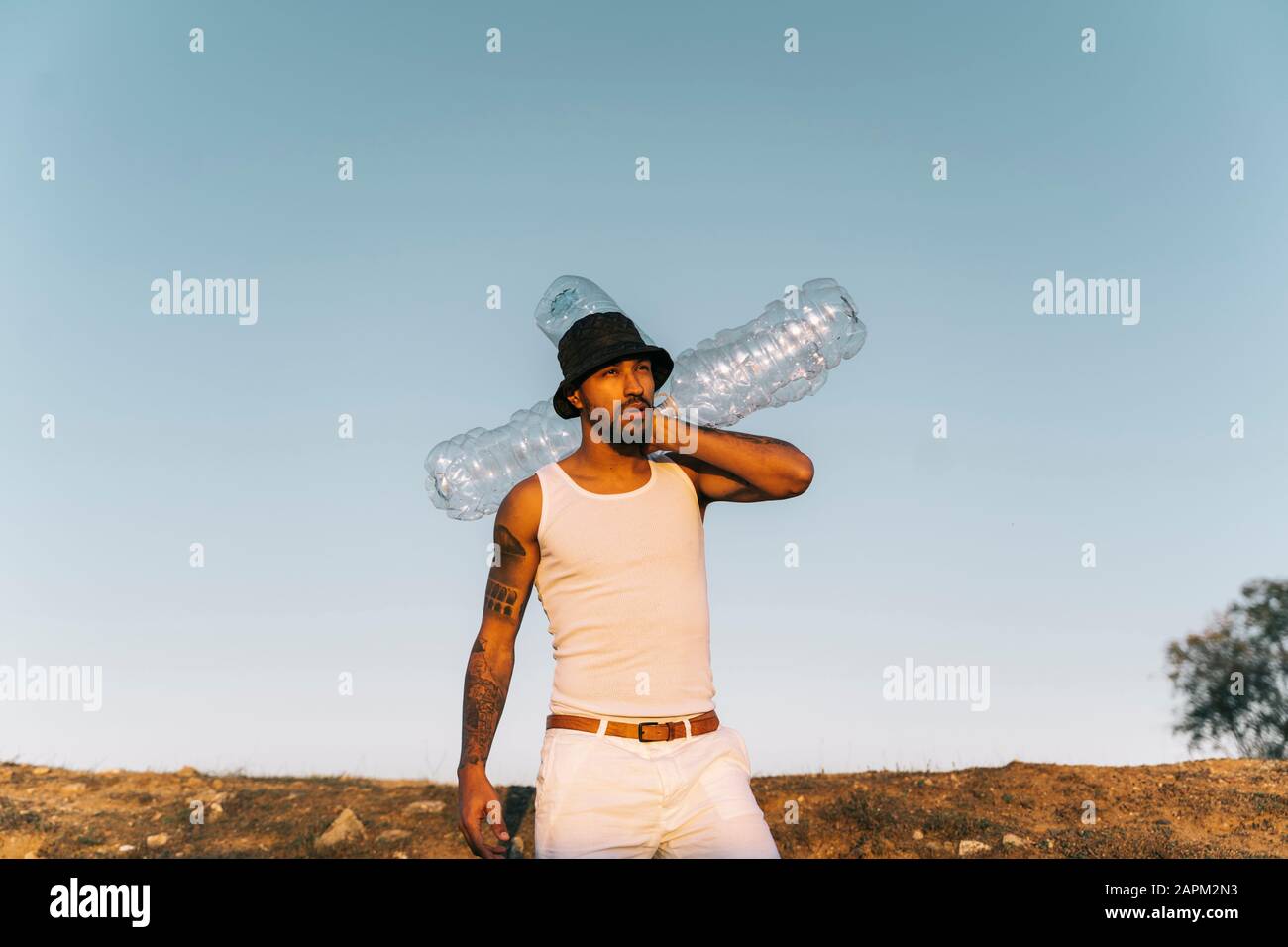 Young man holding empty plastic bottles in barren land Stock Photo - Alamy