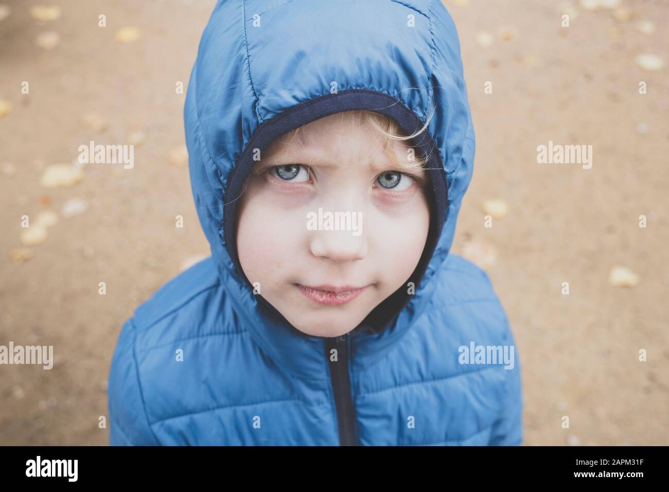 Portrait of grumpy little boy wearing blue anorak Stock Photo - Alamy