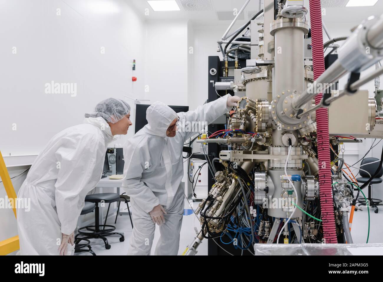 Laboratory technicians working on a device in laboratory of science ...