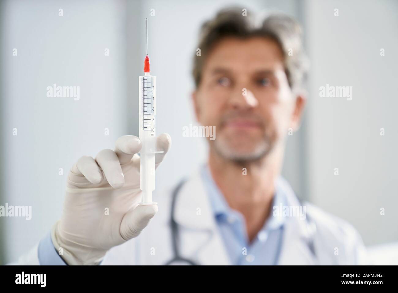 Doctor holding syringe in his medical practice Stock Photo - Alamy