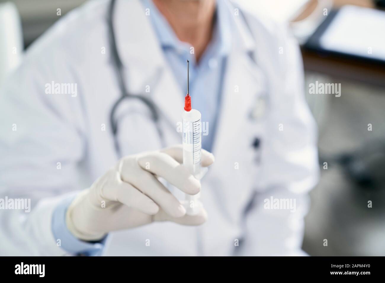 Doctor holding syringe in his medical practice Stock Photo - Alamy