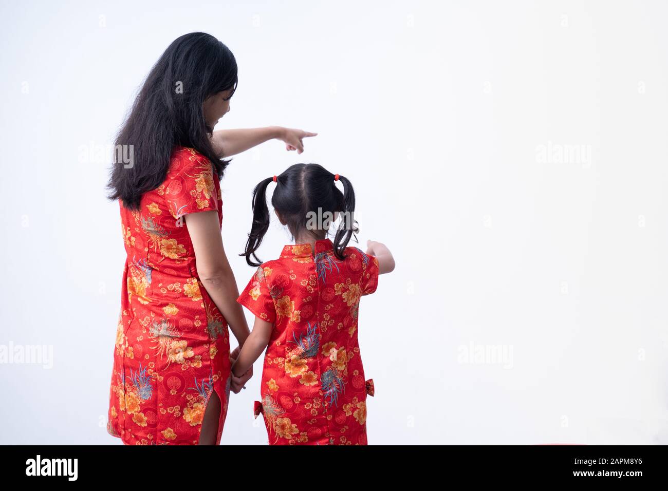 mother and daughter pointing shoot from behind. wearing chinese ...