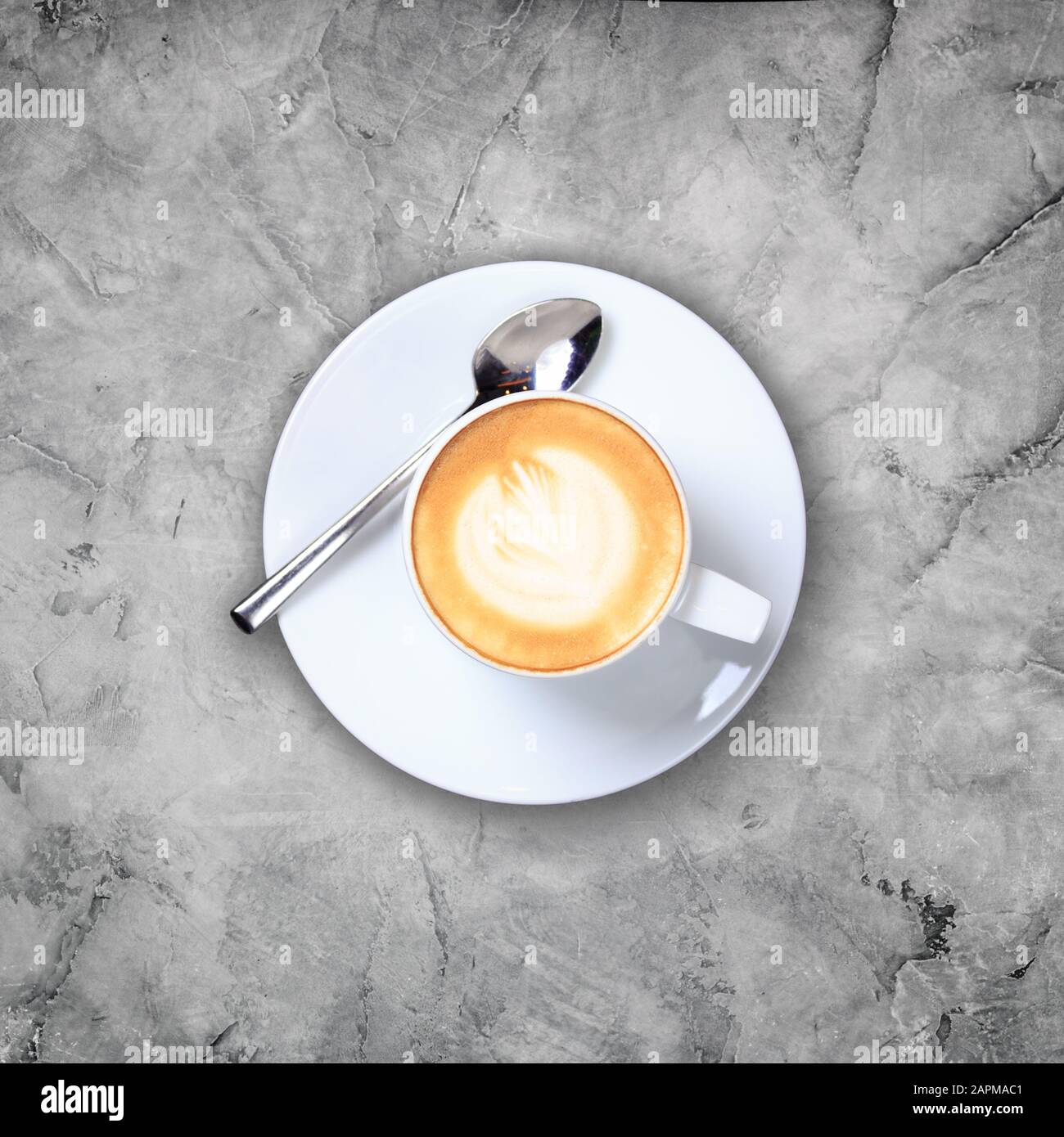Overhead view of cafe latte with craft design on it on the grey marble ...