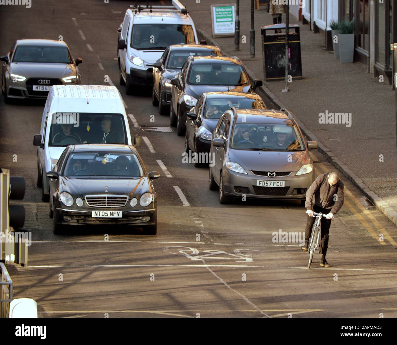 Cyclist on bike waiting at the front of traffic Stock Photo - Alamy