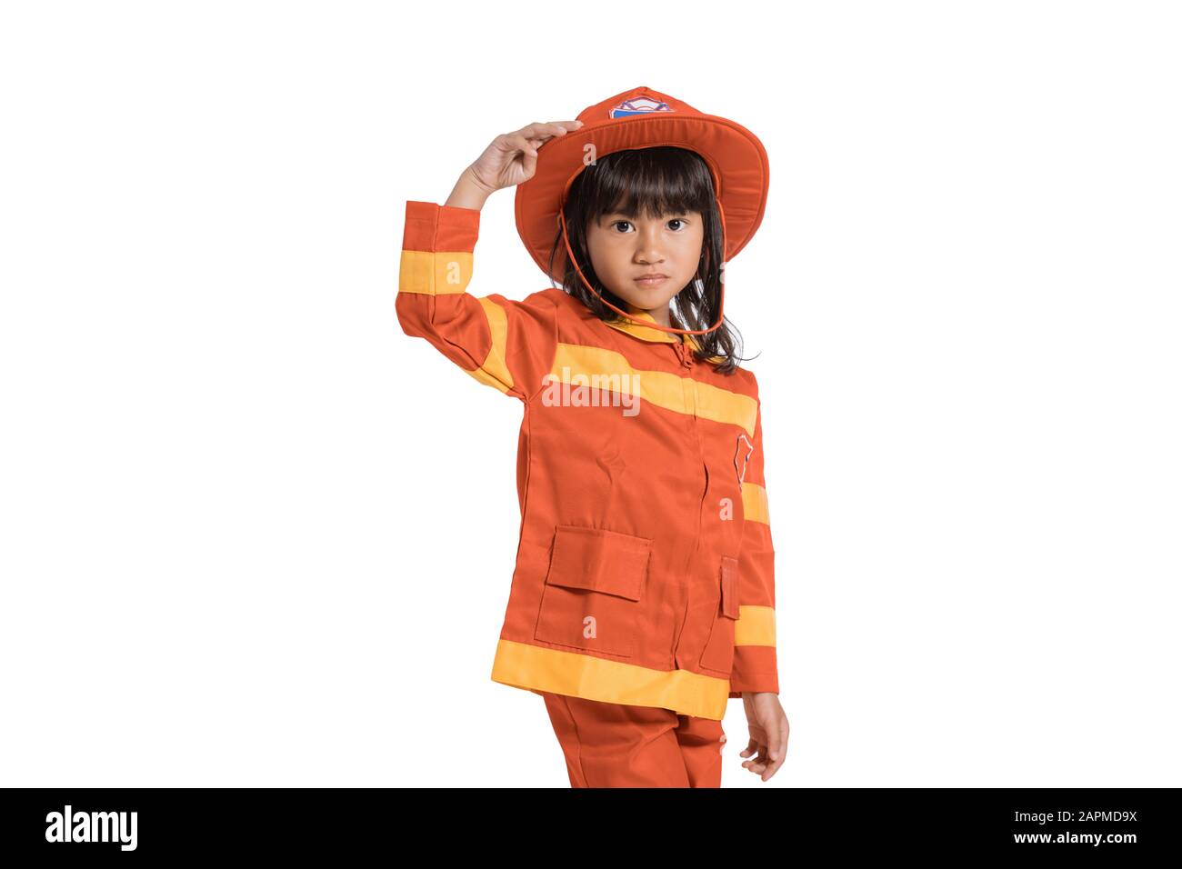 Little girl wearing a firefighter uniform with one hand holding a hat ...
