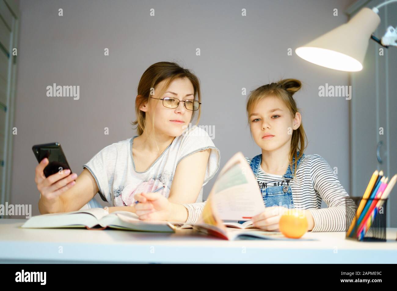 Mother and daughter doing homework together Stock Photo - Alamy