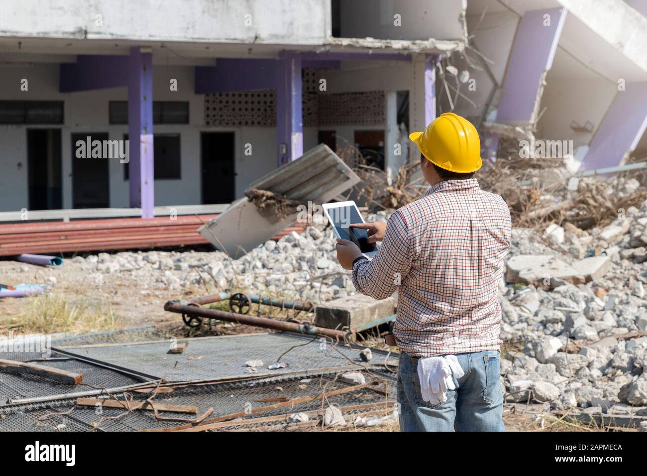 Engineer holding tablet is checking for destruction, demolishing ...