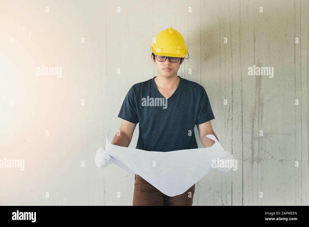 Engineer or Architect holding blueprint in building construction site ...
