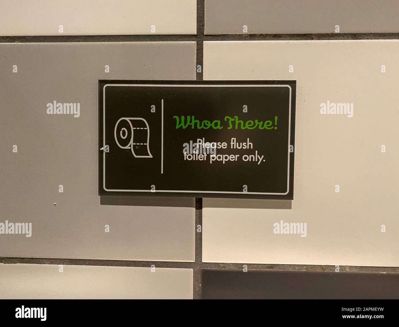 A sign signifying to flush Toilet Paper only in a public bathroom Stock ...