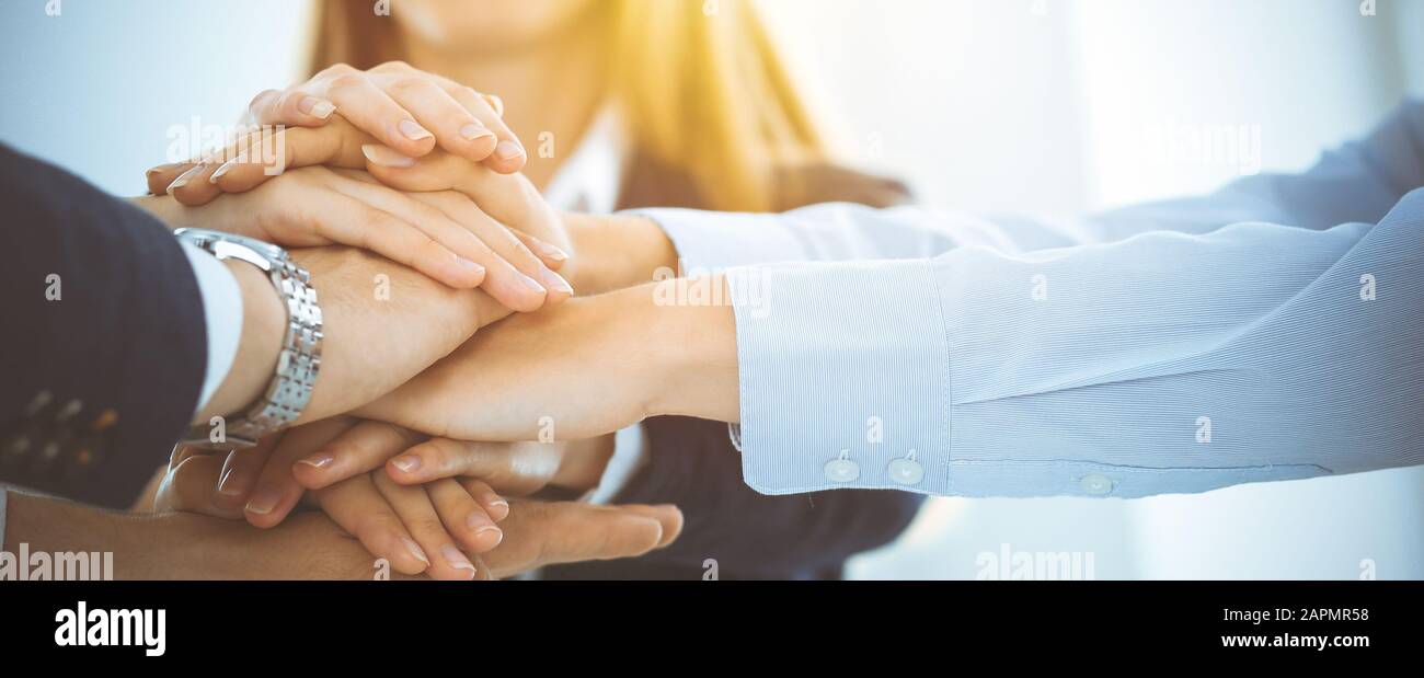 Business team showing unity with their hands together in sunny office ...