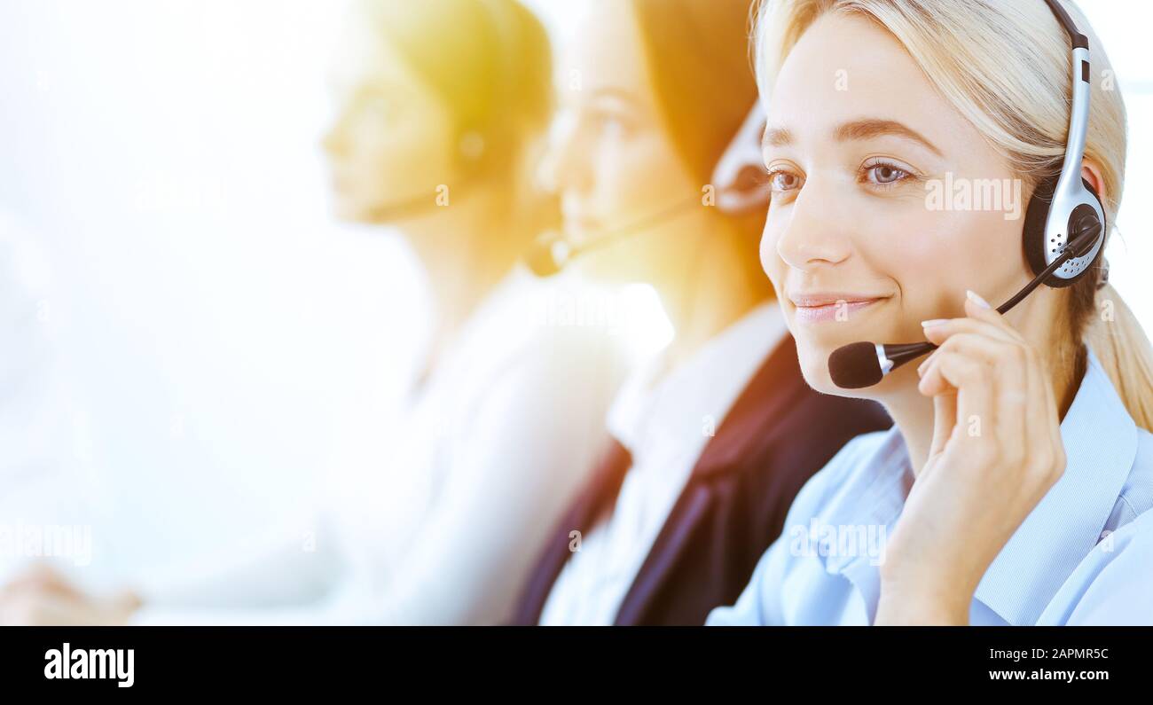Group of diverse phone operators at work in sunny office. Handsome ...