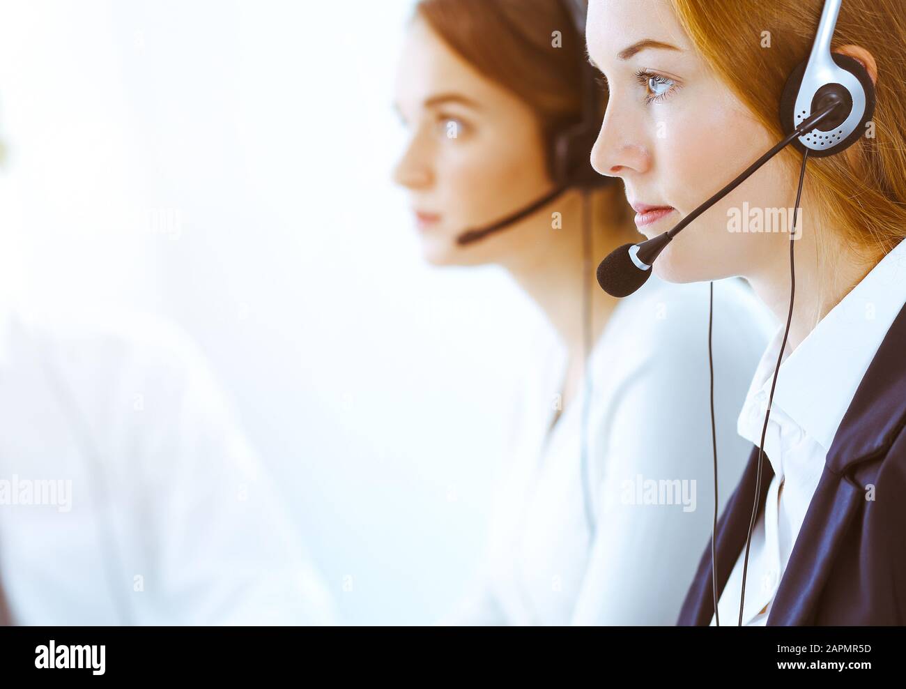 Group of diverse phone operators at work in sunny office. Handsome ...