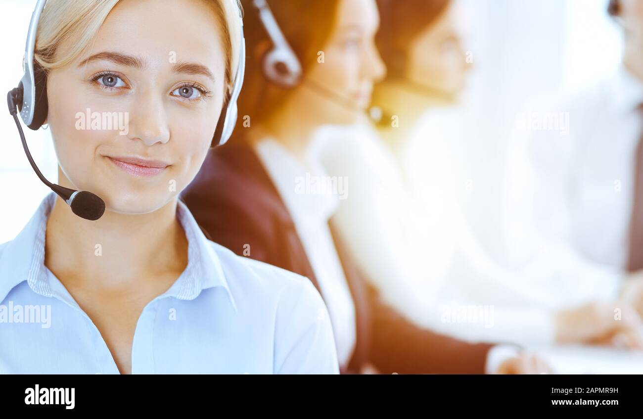 Group of diverse phone operators at work in sunny office. Handsome ...