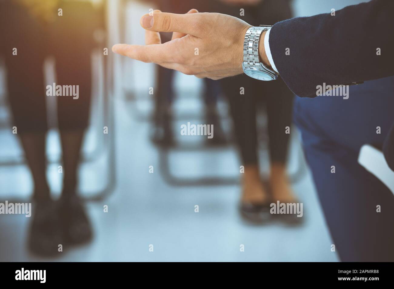 Business man making presentation to group of people in sunny office ...