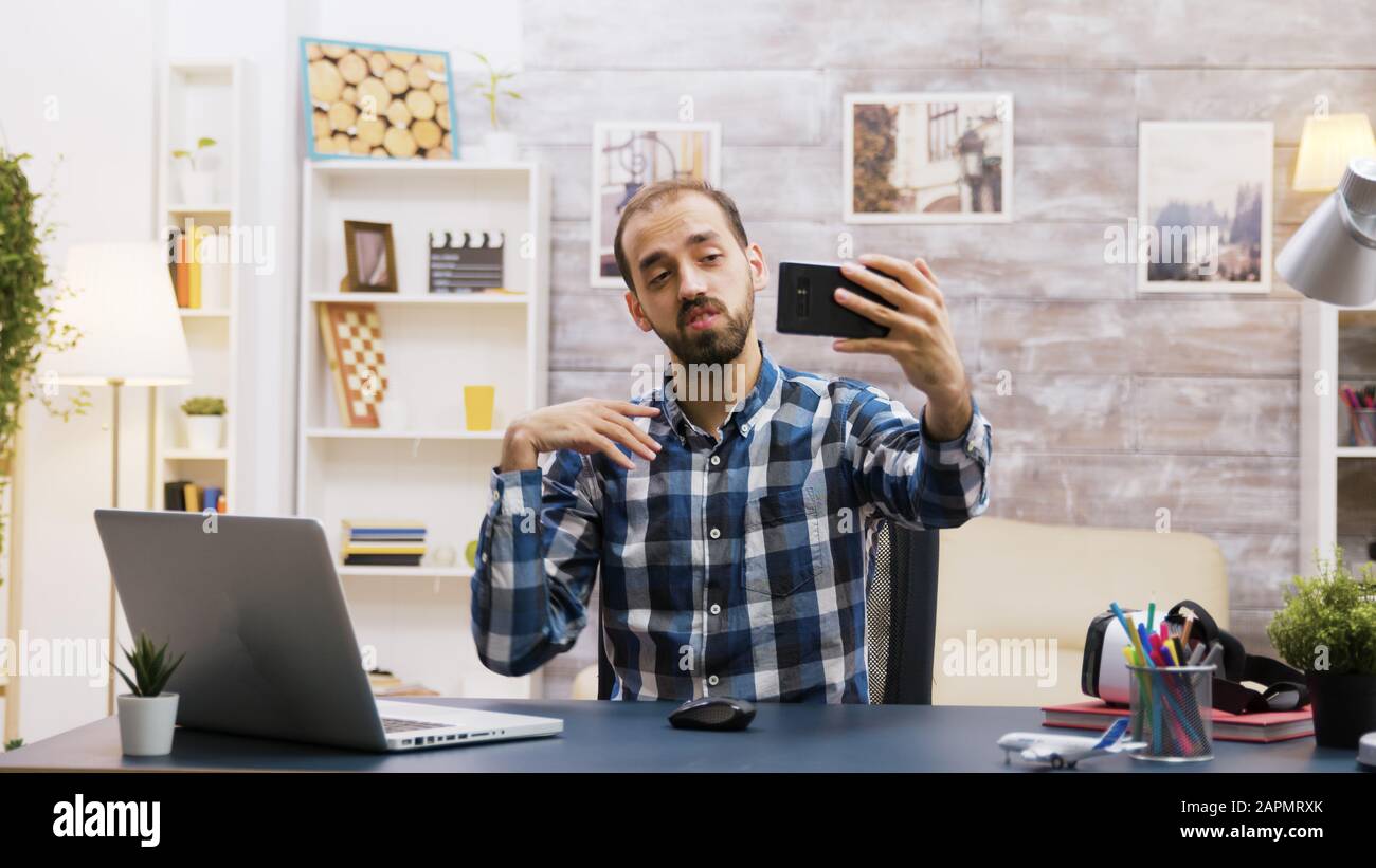 Creative young man using his phone to record a new episode for social ...