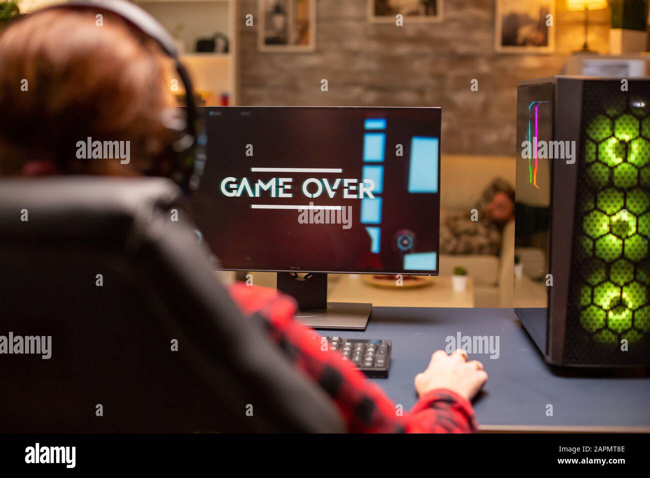 Gamer woman losing at a video game playing late at night in the living ...