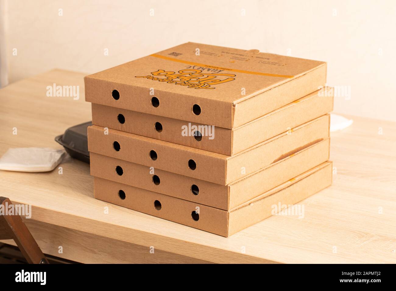 Pizza box: tall stack, brown on the dining table Stock Photo - Alamy