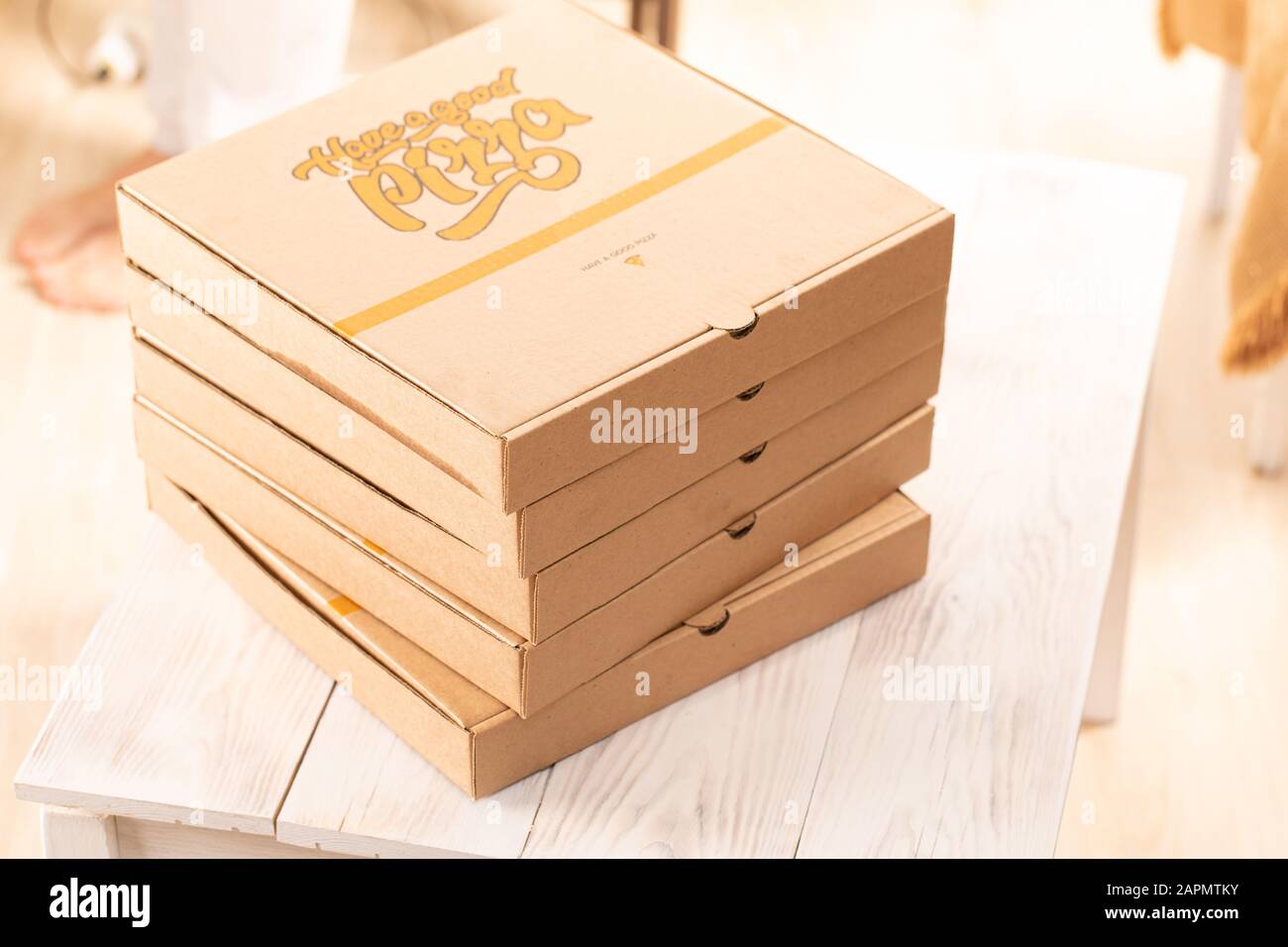 Pizza box, stack, brown, front view. on dining table Stock Photo - Alamy